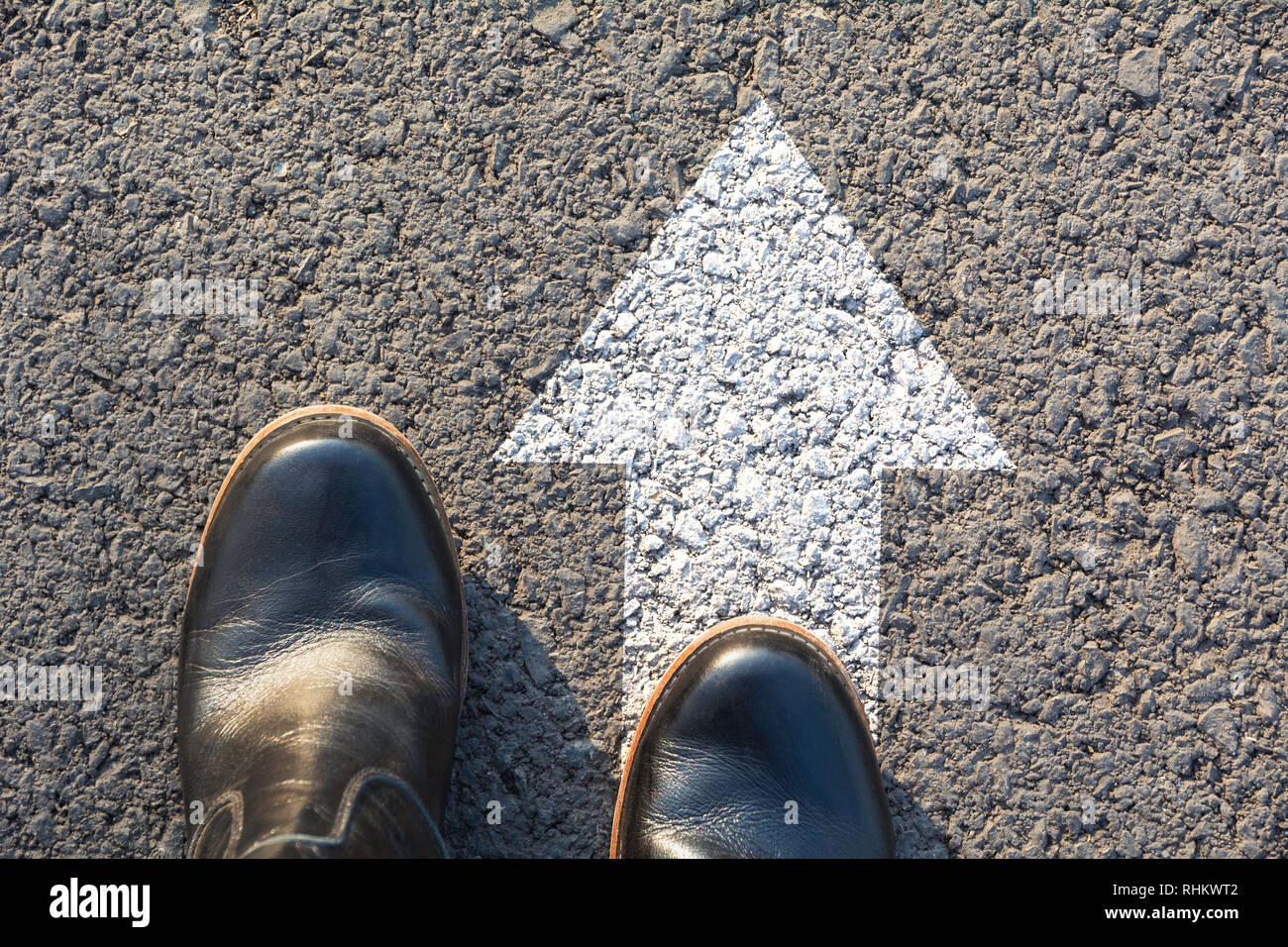 Top view of man wearing black shoes choosing a way marked with white ...