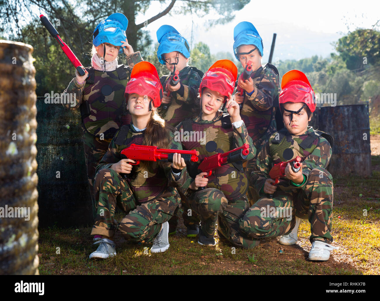 Friendly cheerful smiling group of children paintball players in ...