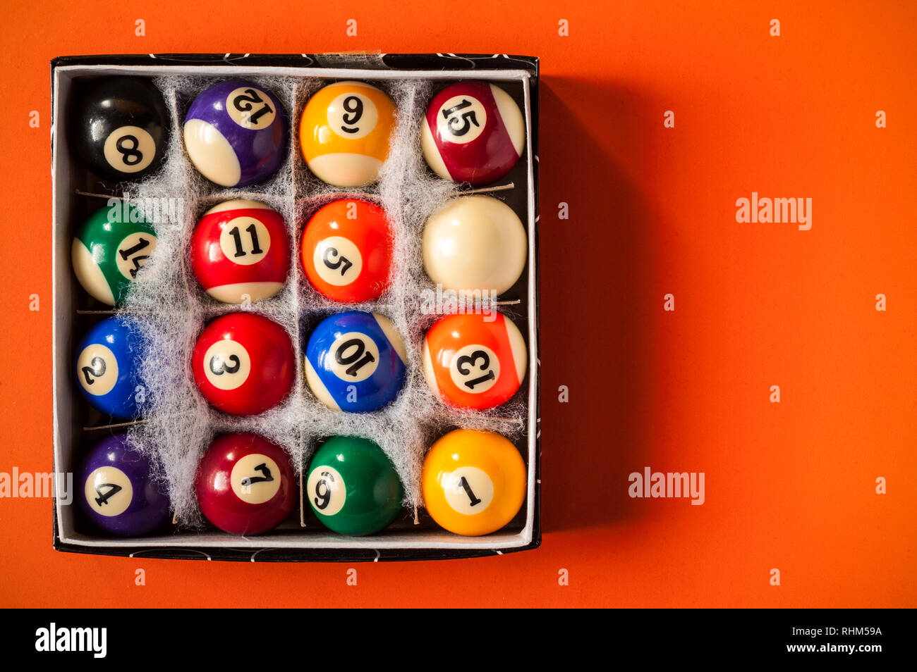 colored billiard balls in a new package on an orange background Stock ...