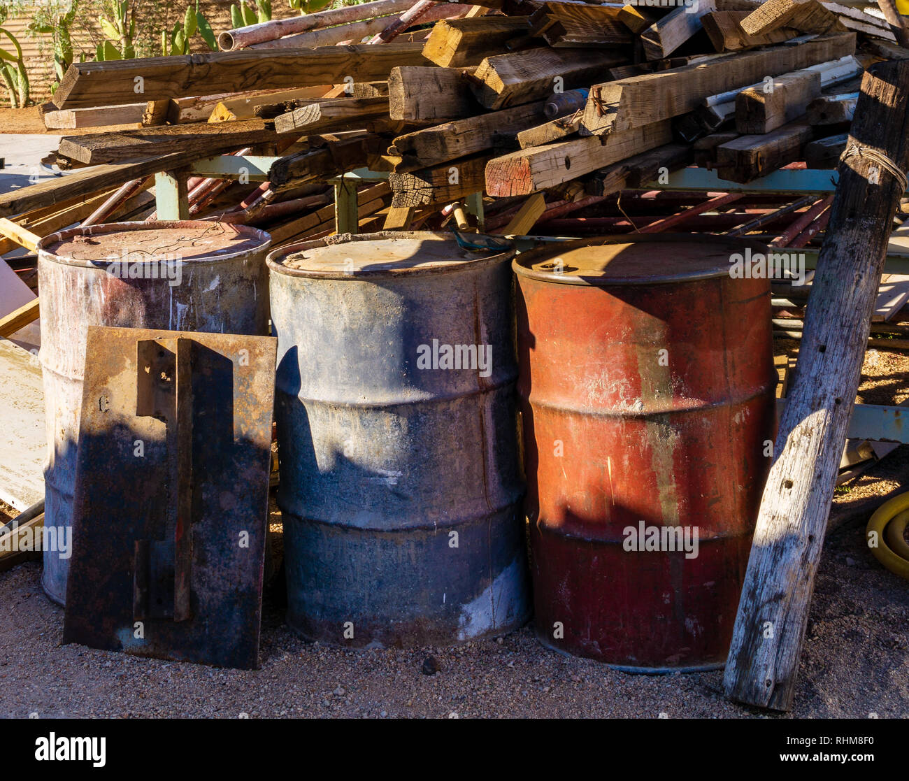Rusty barrel oil on a partly black coloured beach illustrates the ...