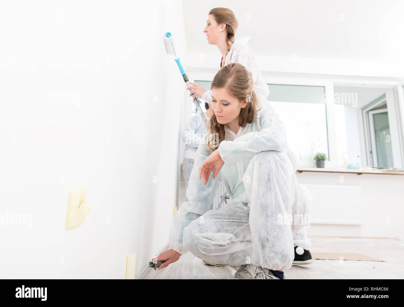 Two female worker painting the wall Stock Photo - Alamy