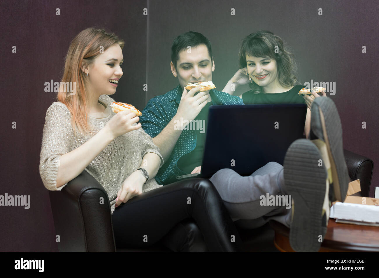 A man and two women are watching a movie on a computer Stock Photo - Alamy