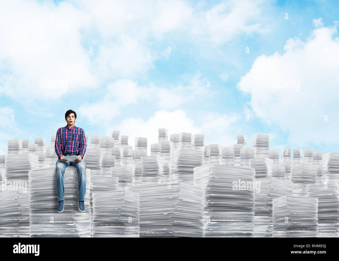 Attractive man sitting on pile of paper documents Stock Photo - Alamy