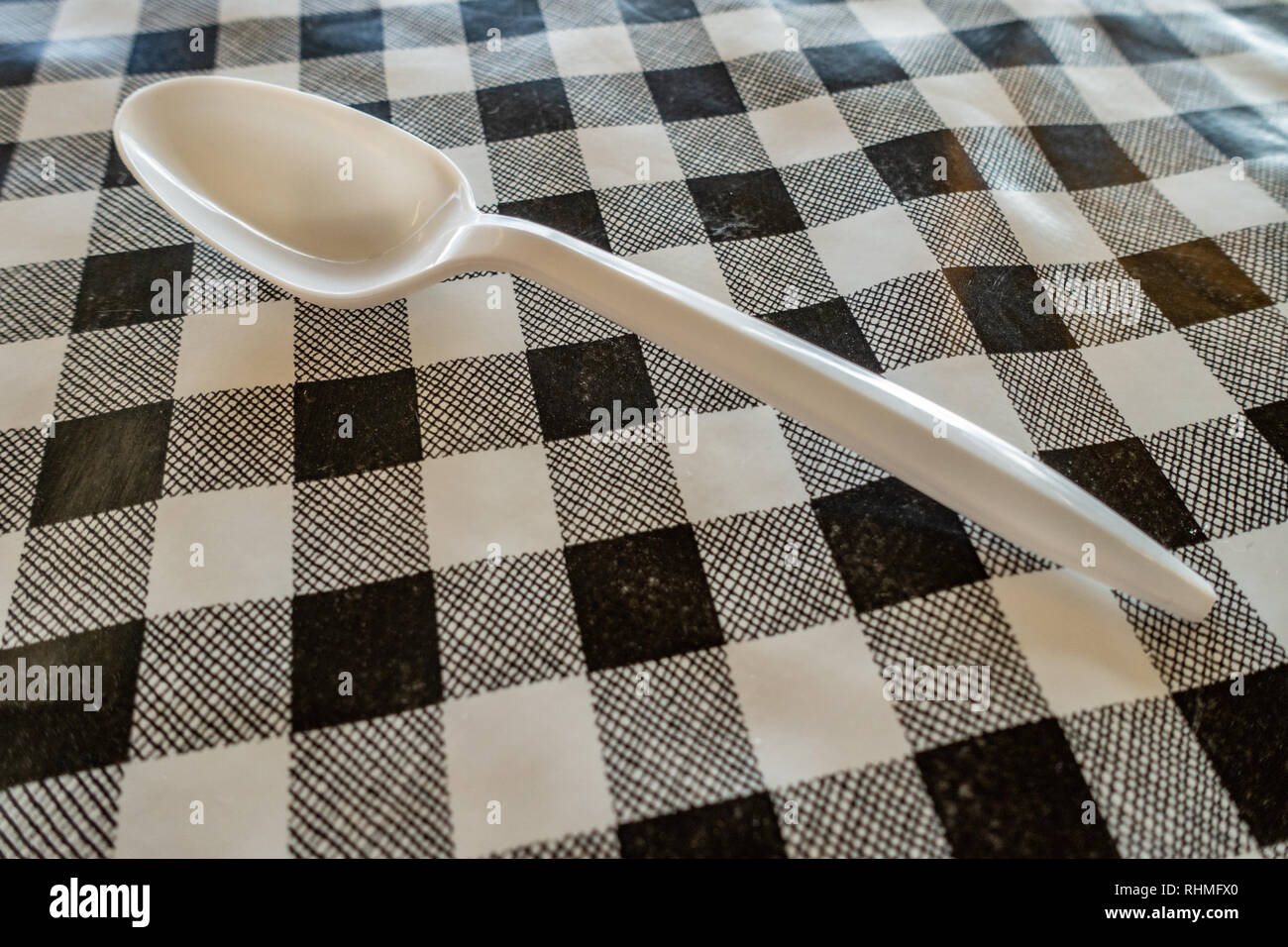 Closeup of single White Plastic disposable tea spoon on a plastic ...