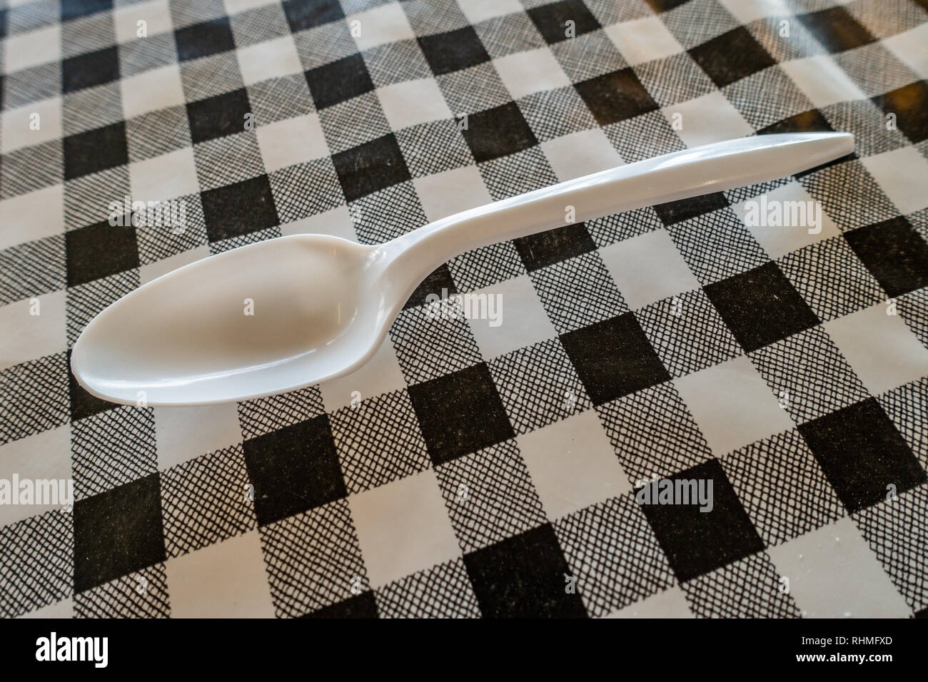 Closeup of single White Plastic disposable tea spoon on a plastic ...