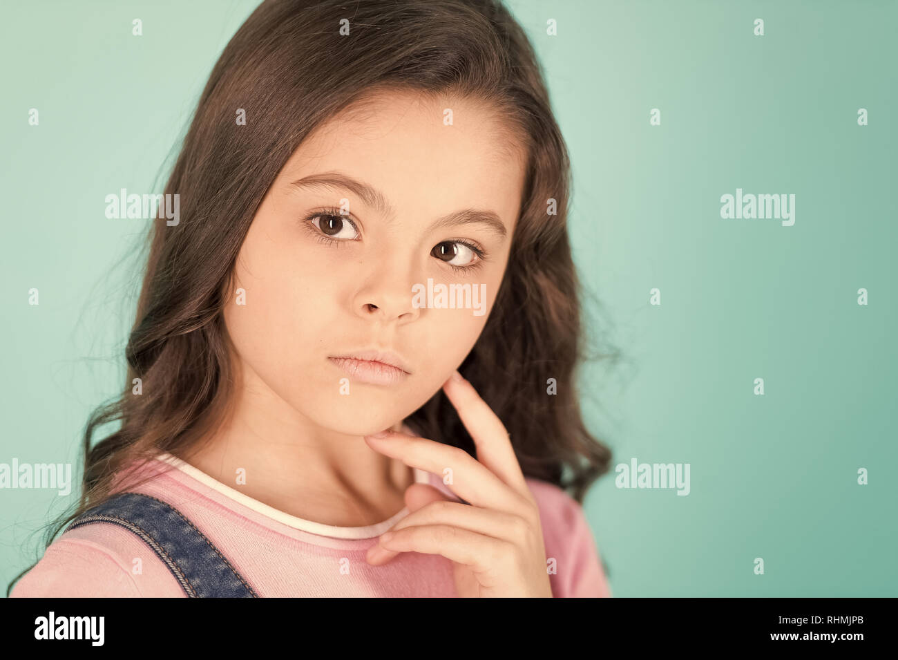 Beautiful little girl looking up and thinking Stock Photo - Alamy