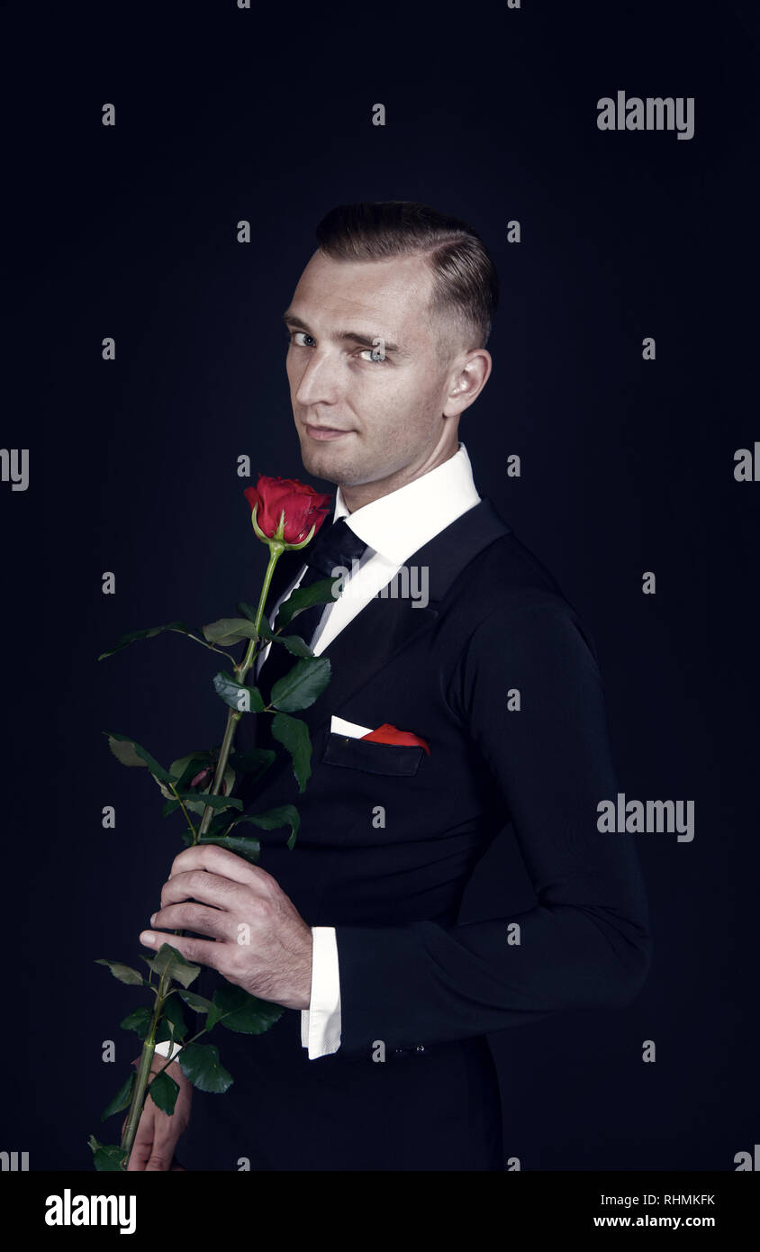 romantic love concept. Man with red rose on dark background. Man dancer ...