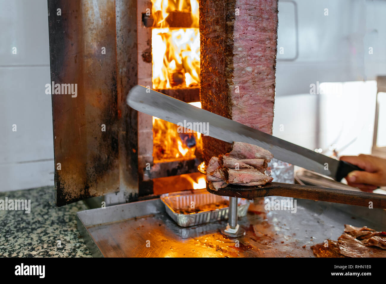 Turkish Doner Kebab, Shawarma or Gyros. Chef cutting with doner knife ...