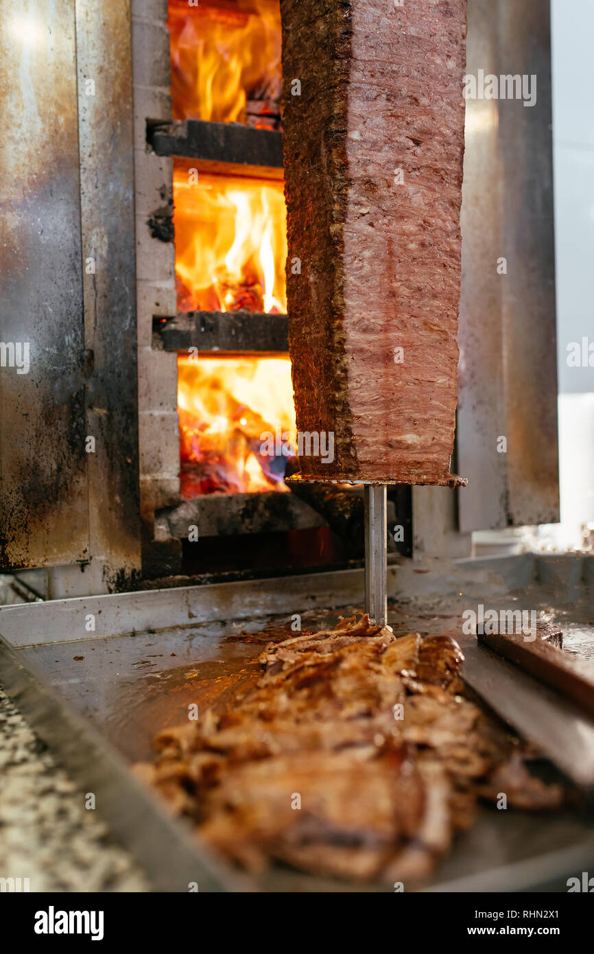Turkish Doner Kebab, Shawarma or Gyros. Chef cutting with doner knife ...