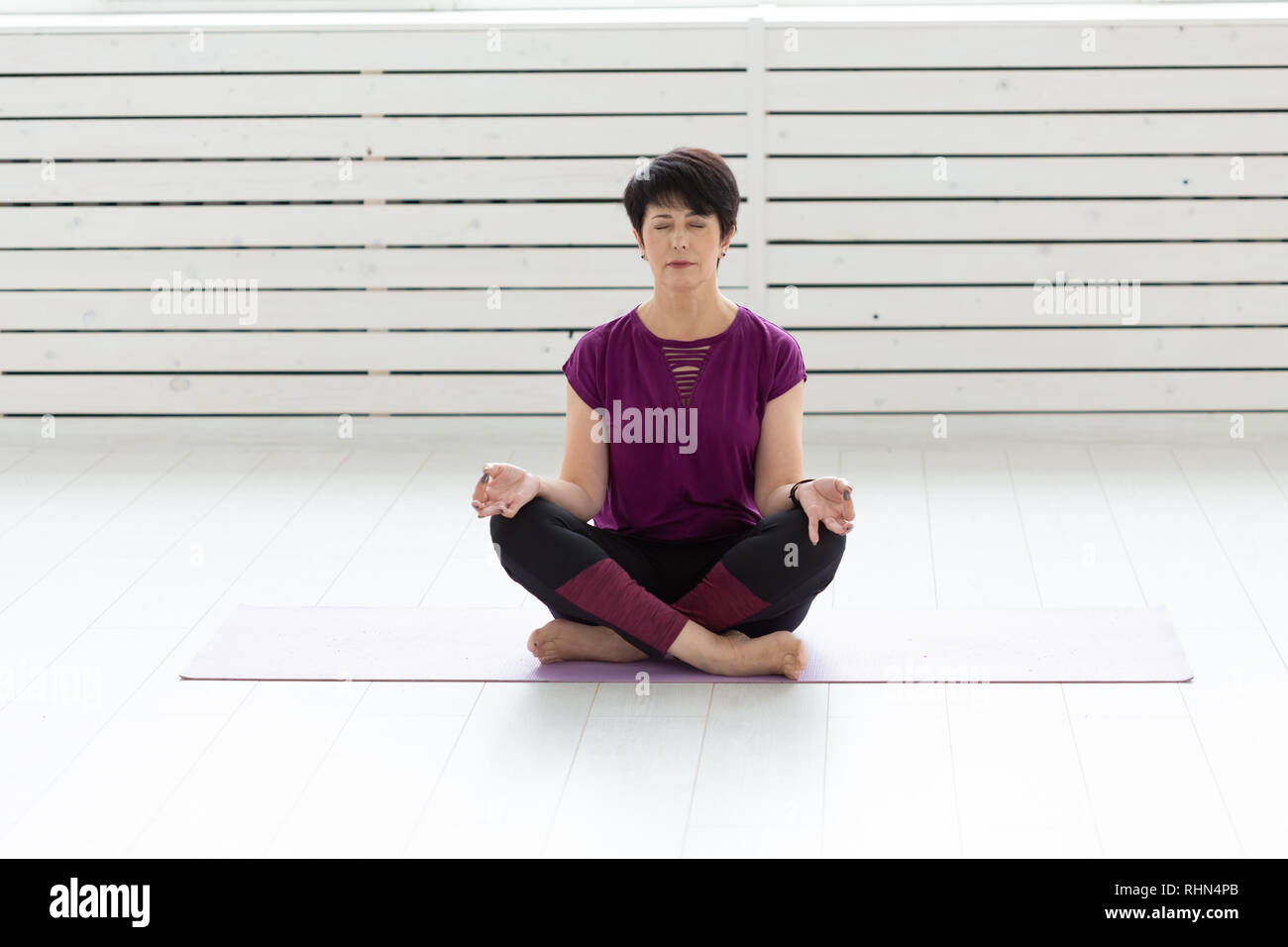 Yoga, harmony, people concept - Middle aged woman sitting in lotus ...