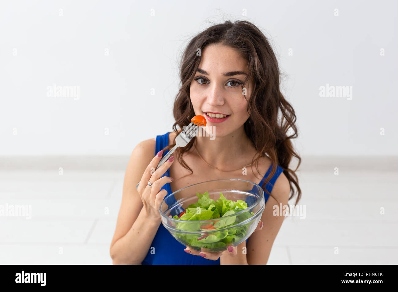 Food, healthy lifestyle, people concept - Young woman eating salad and ...