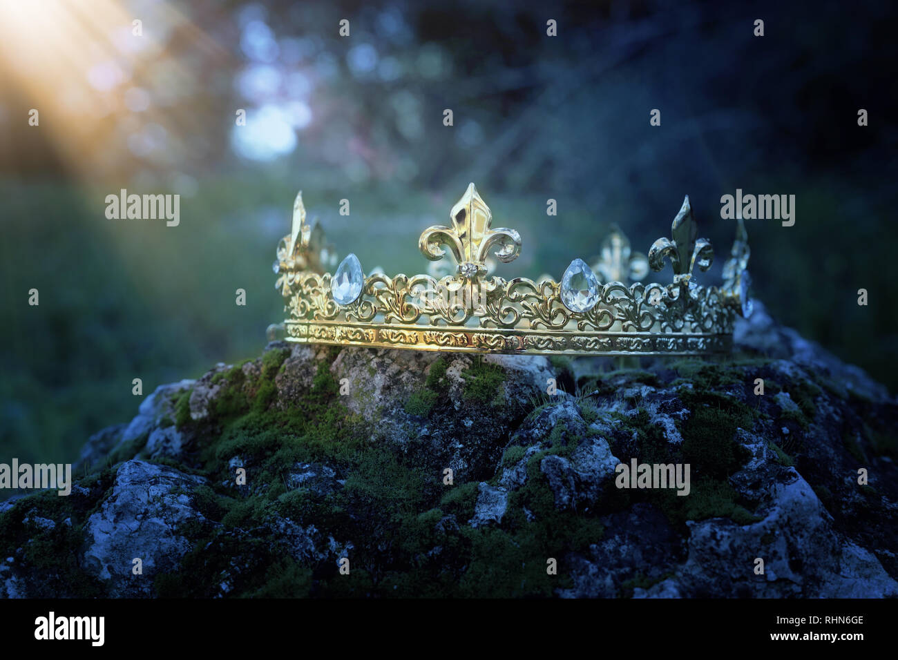 mysterious and magical photo of gold king crown over the stone covered ...