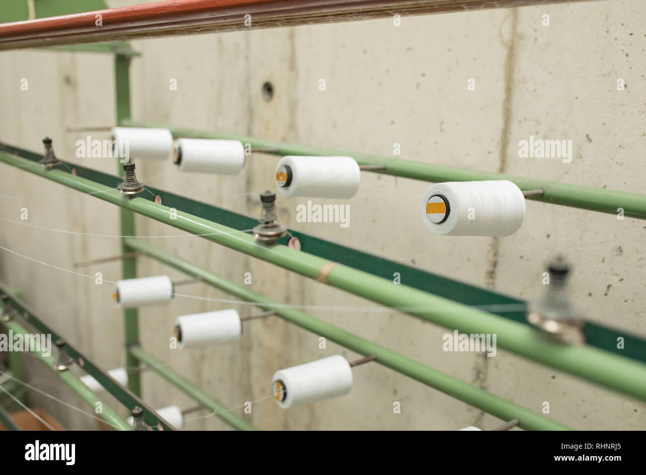 Group of bobbin thread cones on a warping machine in a textile mill ...