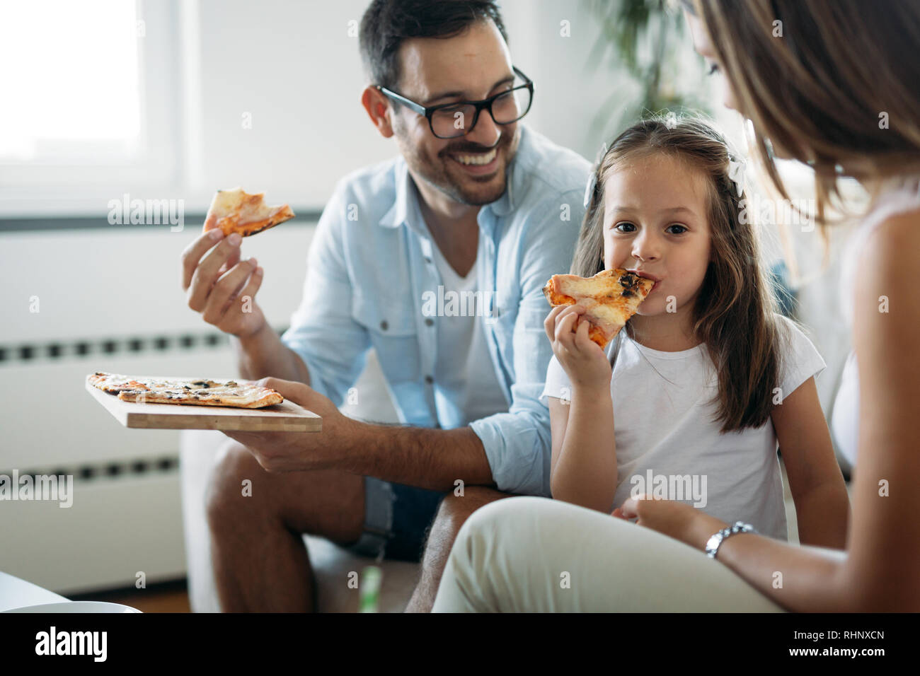 Portrait of happy family sharing pizza at home Stock Photo - Alamy