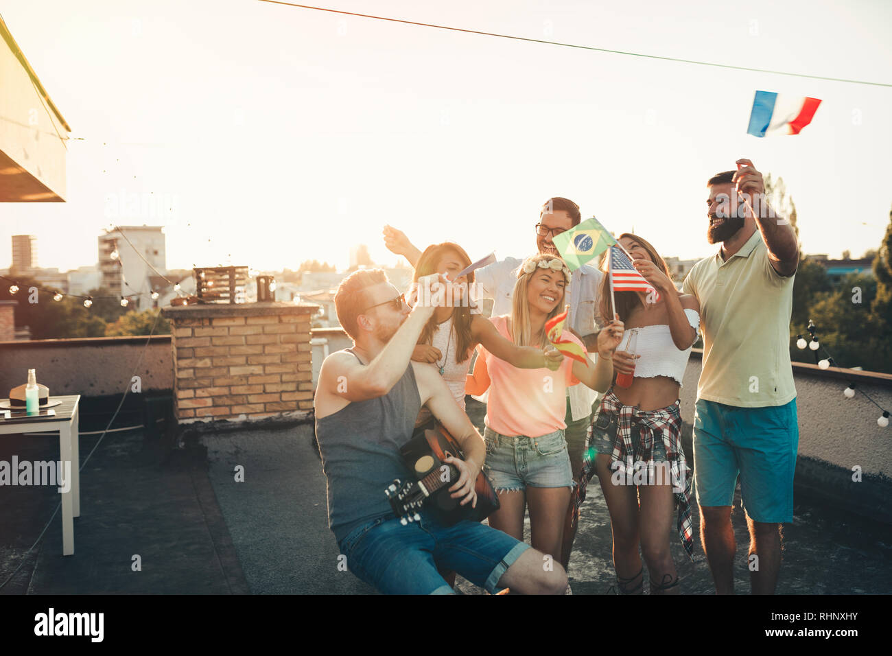 Group of happy friends having party on rooftop Stock Photo - Alamy