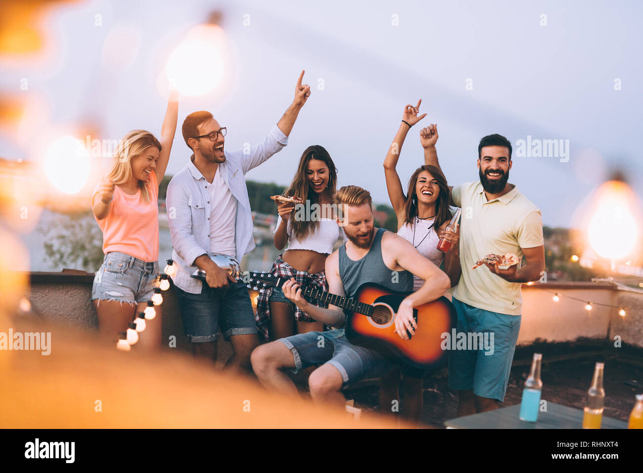 Group of happy friends having party on rooftop Stock Photo - Alamy