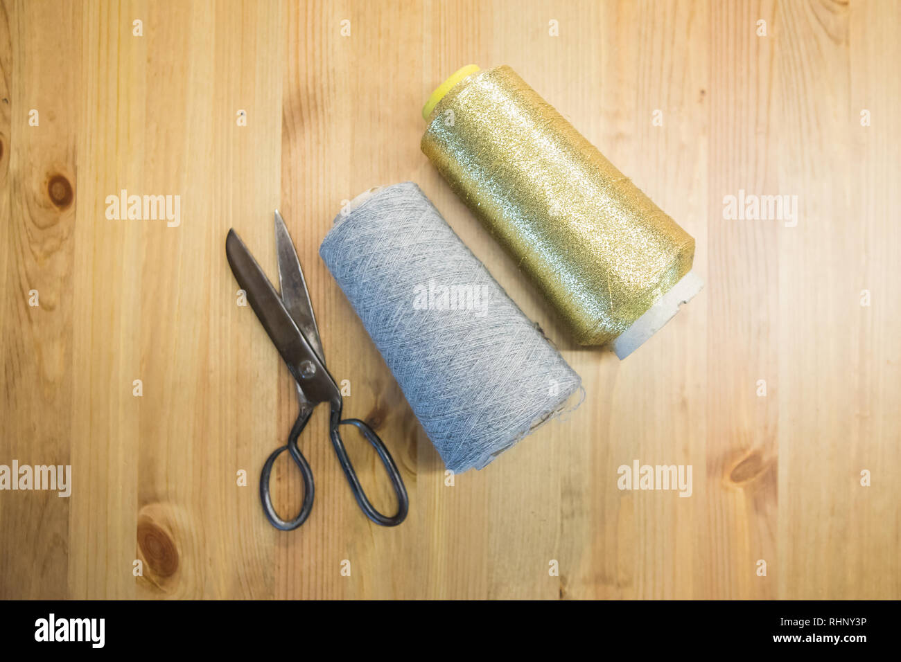 Scissors and yarn bobbin spools of threads. Textile industry concept ...