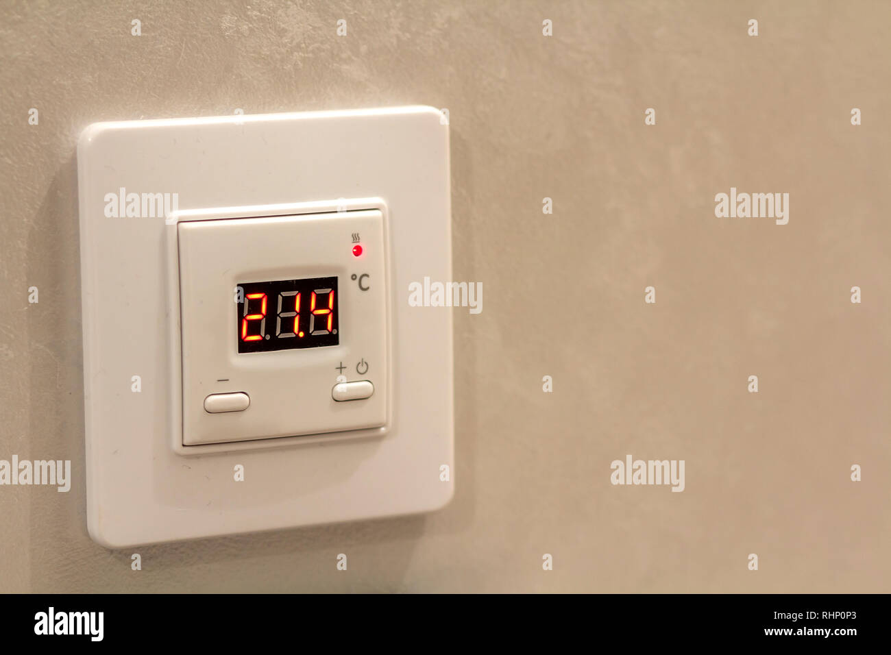 White electronic programmable digital thermostat on light wall copy ...