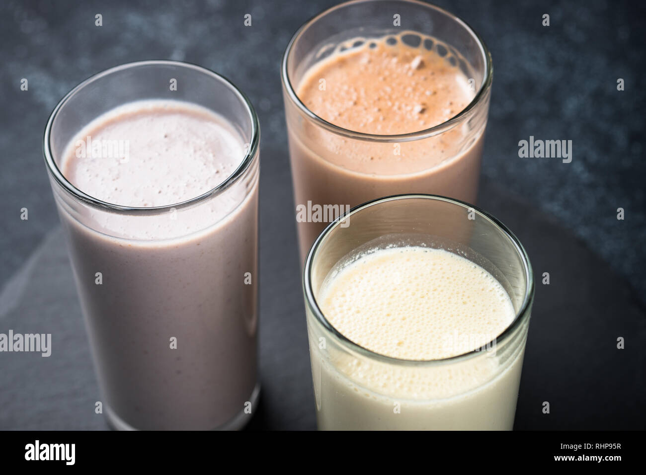 Protein cocktails on black. Vanilla, berry and chocolate protein shakes ...