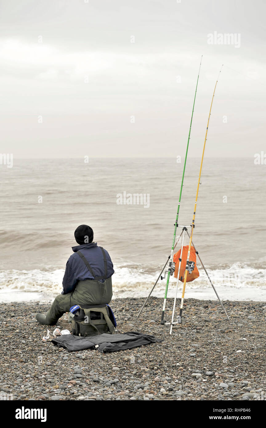 Sea angler fishing for cod on a January day with a rough sea Stock ...