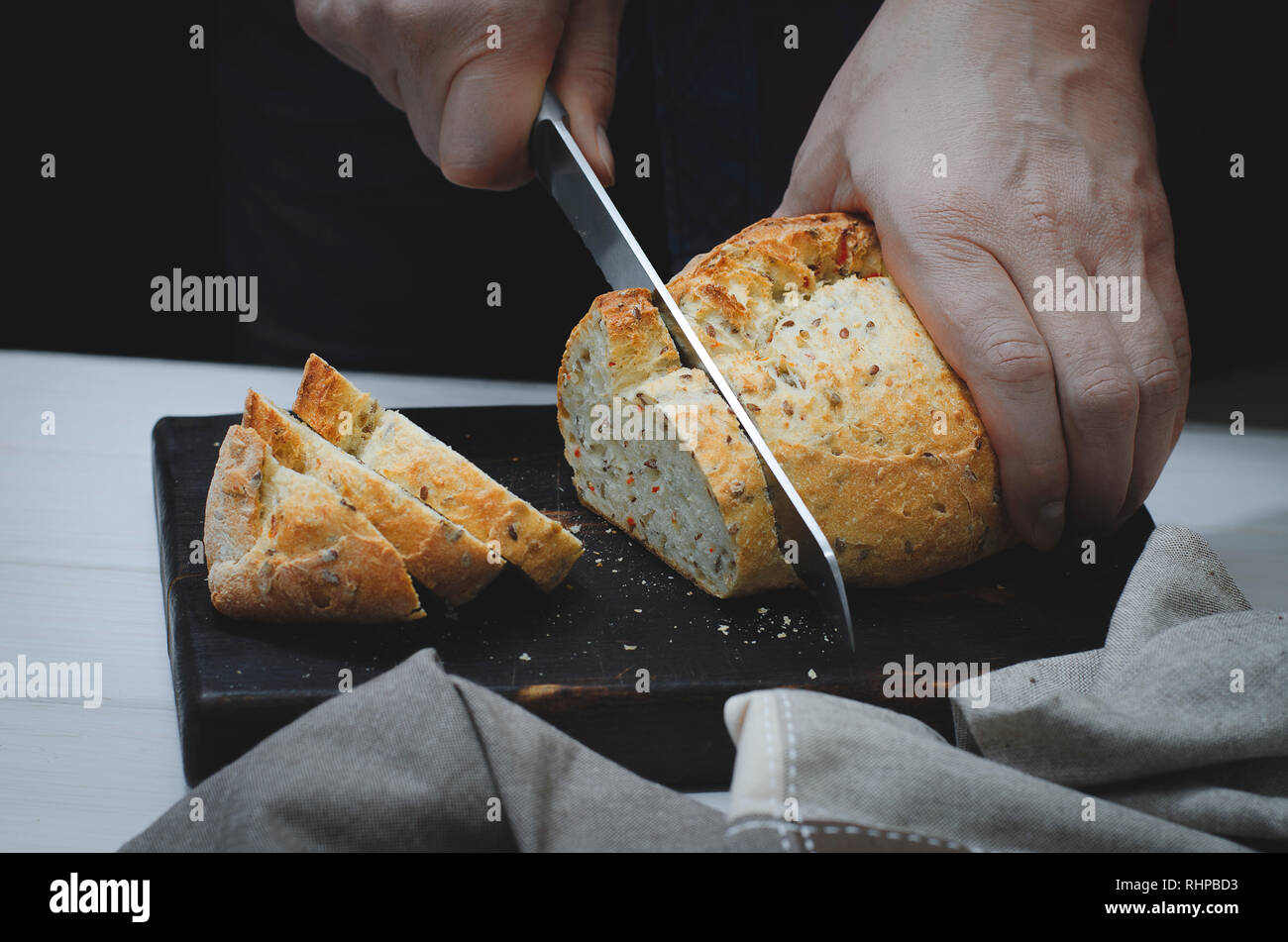Whole grain bread put on kitchen wood plate with a chef holding gold ...