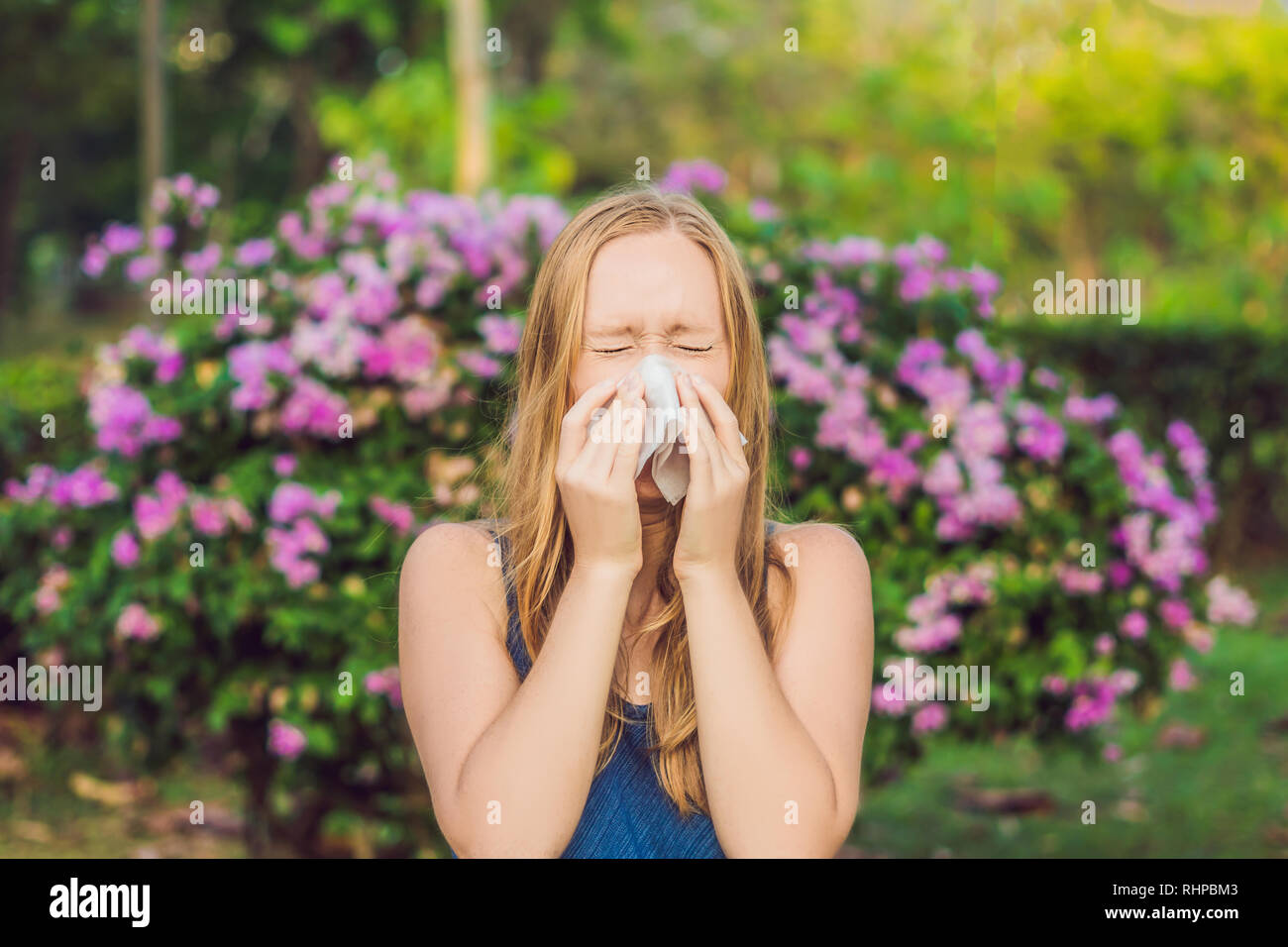 Pollen allergy concept. Young woman is going to sneeze. Flowering trees in background Stock ...