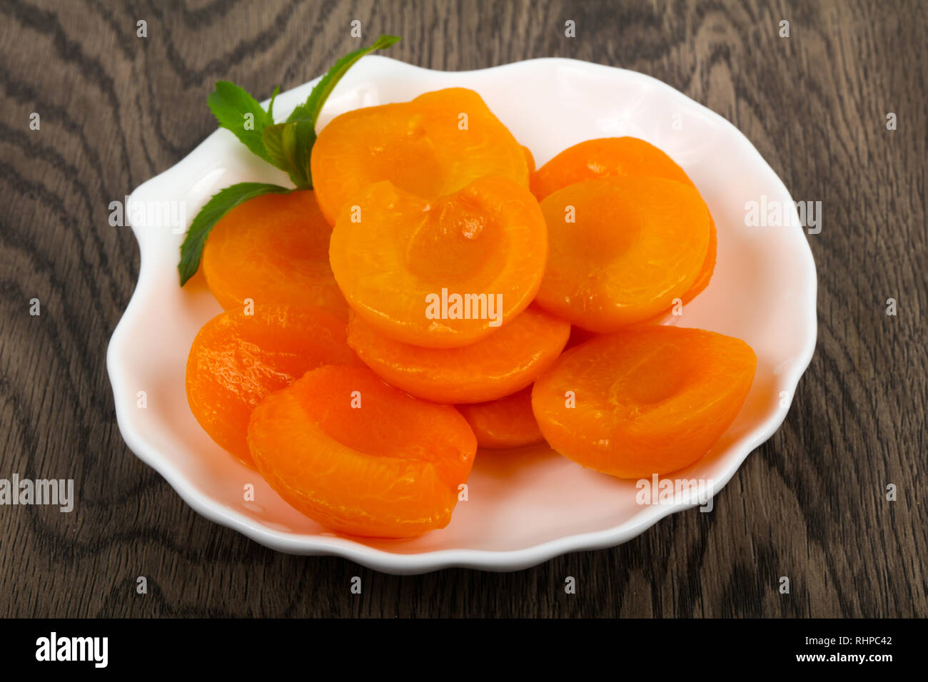 Canned apricots with mint leaves Stock Photo - Alamy