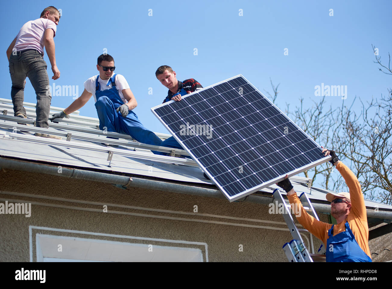 Male team workers installing stand-alone solar photovoltaic panel ...