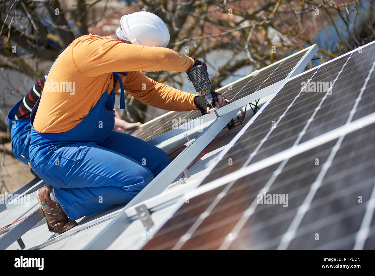 Male worker in protective helmet installing stand-alone solar ...