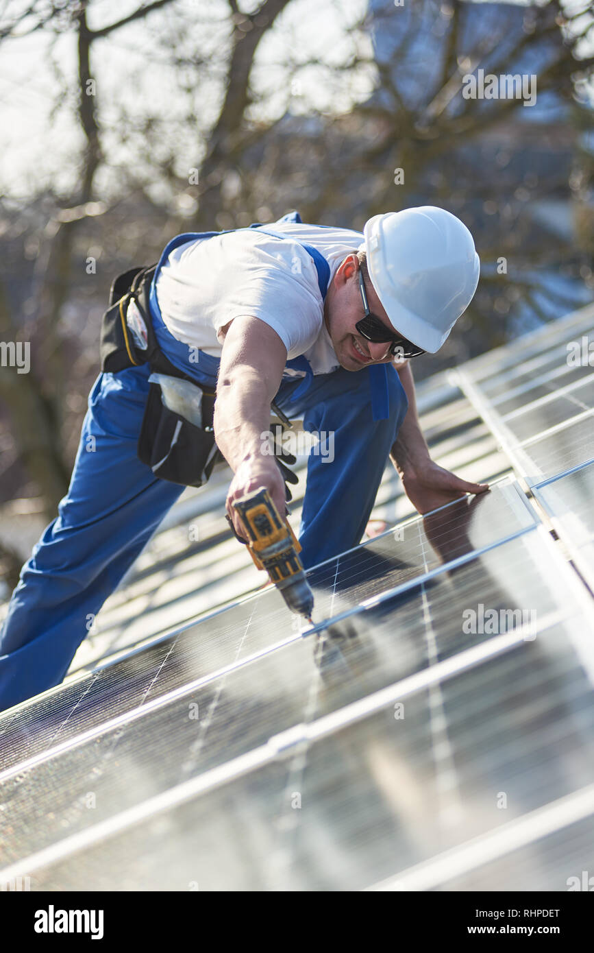 Male engineer installing stand-alone solar photovoltaic panel system ...