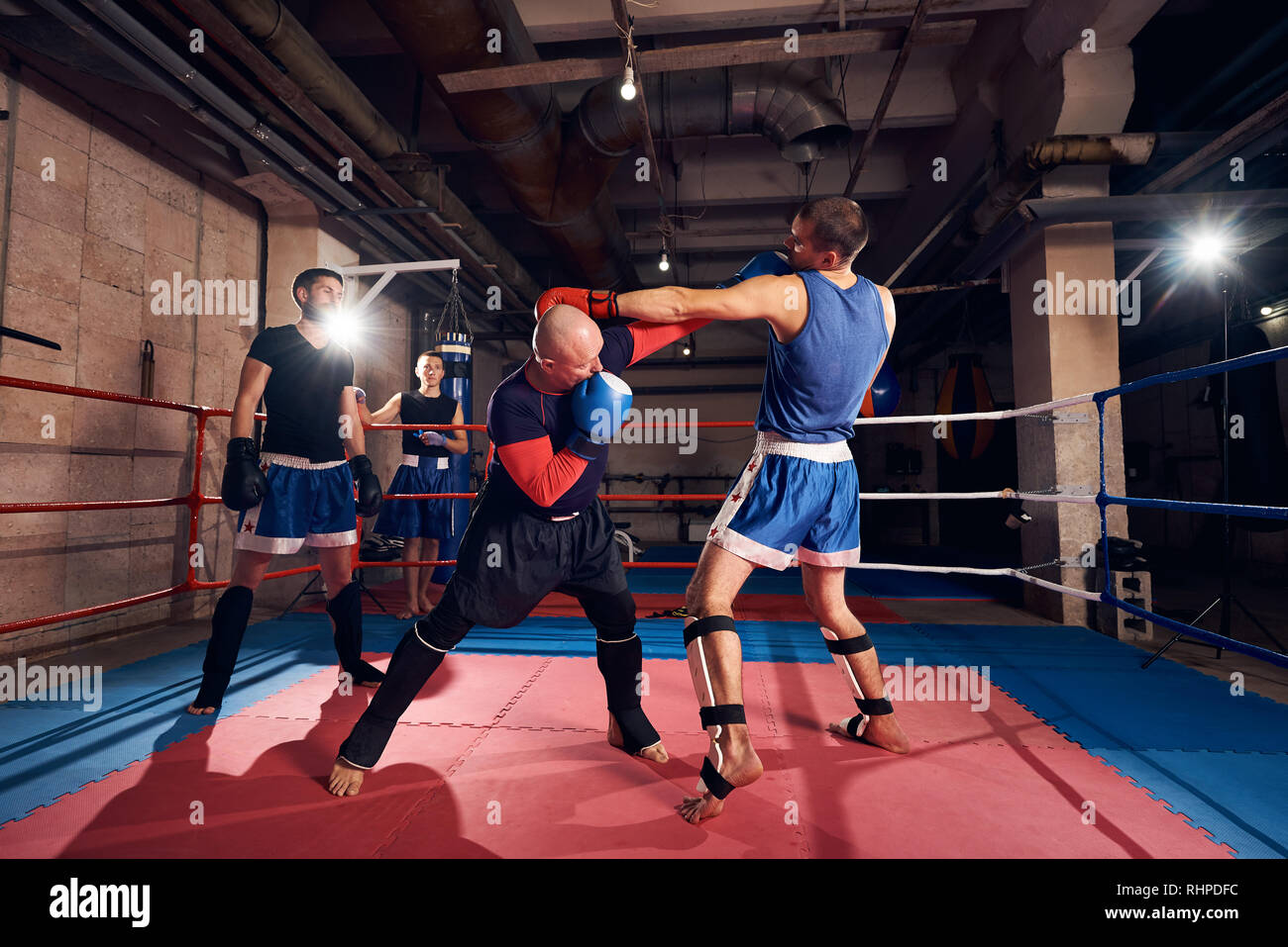 Athlete man boxer training kickboxing with trainer in the ring at the ...