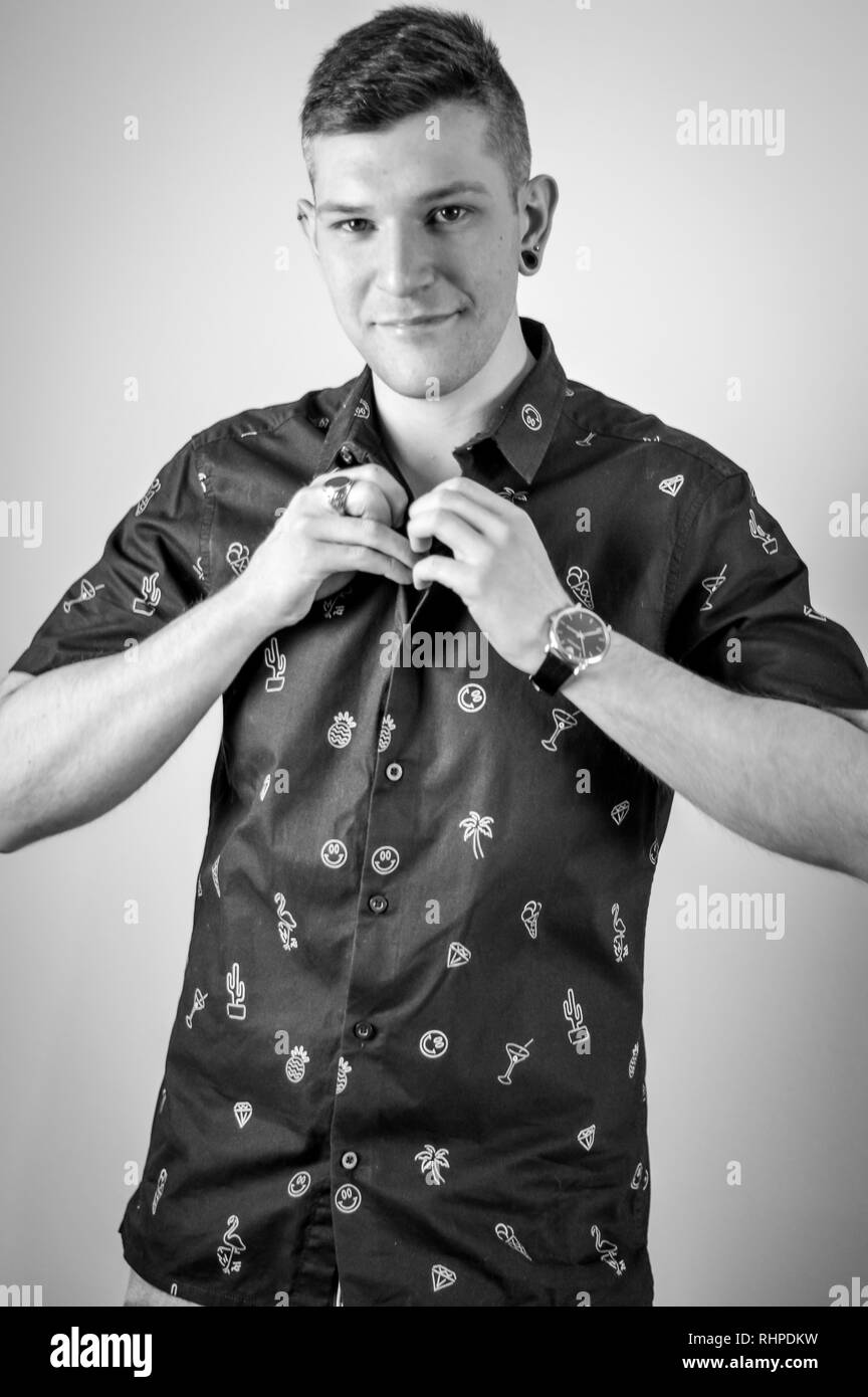 Portrait of a young man adjusting his shirt Stock Photo - Alamy