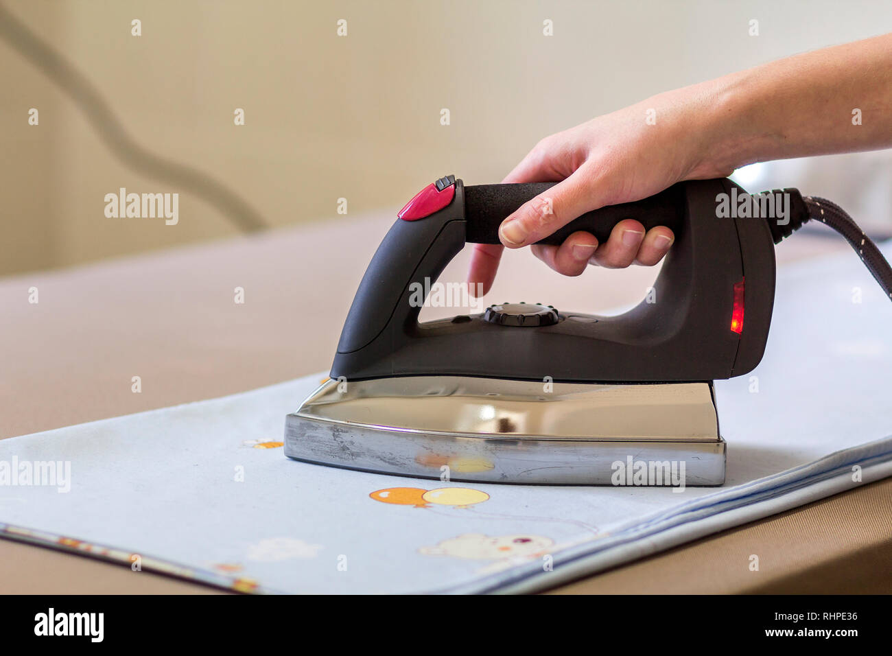 Close-up of female handle ironing clothing using new modern stainless ...