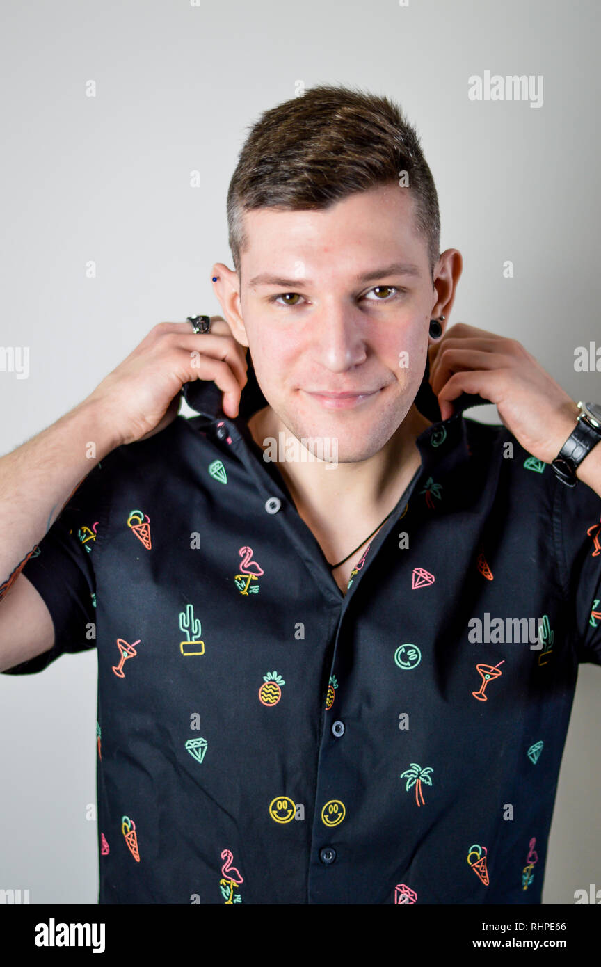 Portrait of a young man adjusting his shirt Stock Photo - Alamy