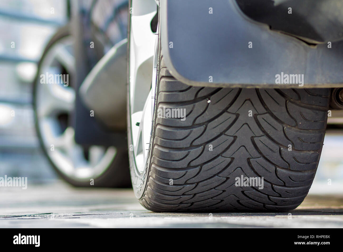 Back view detail part of black shiny luxurious car tire parked on ...