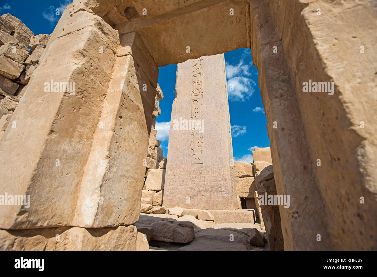 Large tall ancient egyptian obelisk at the temple of Karnak in Luxor with hieroglyphic carvings ...