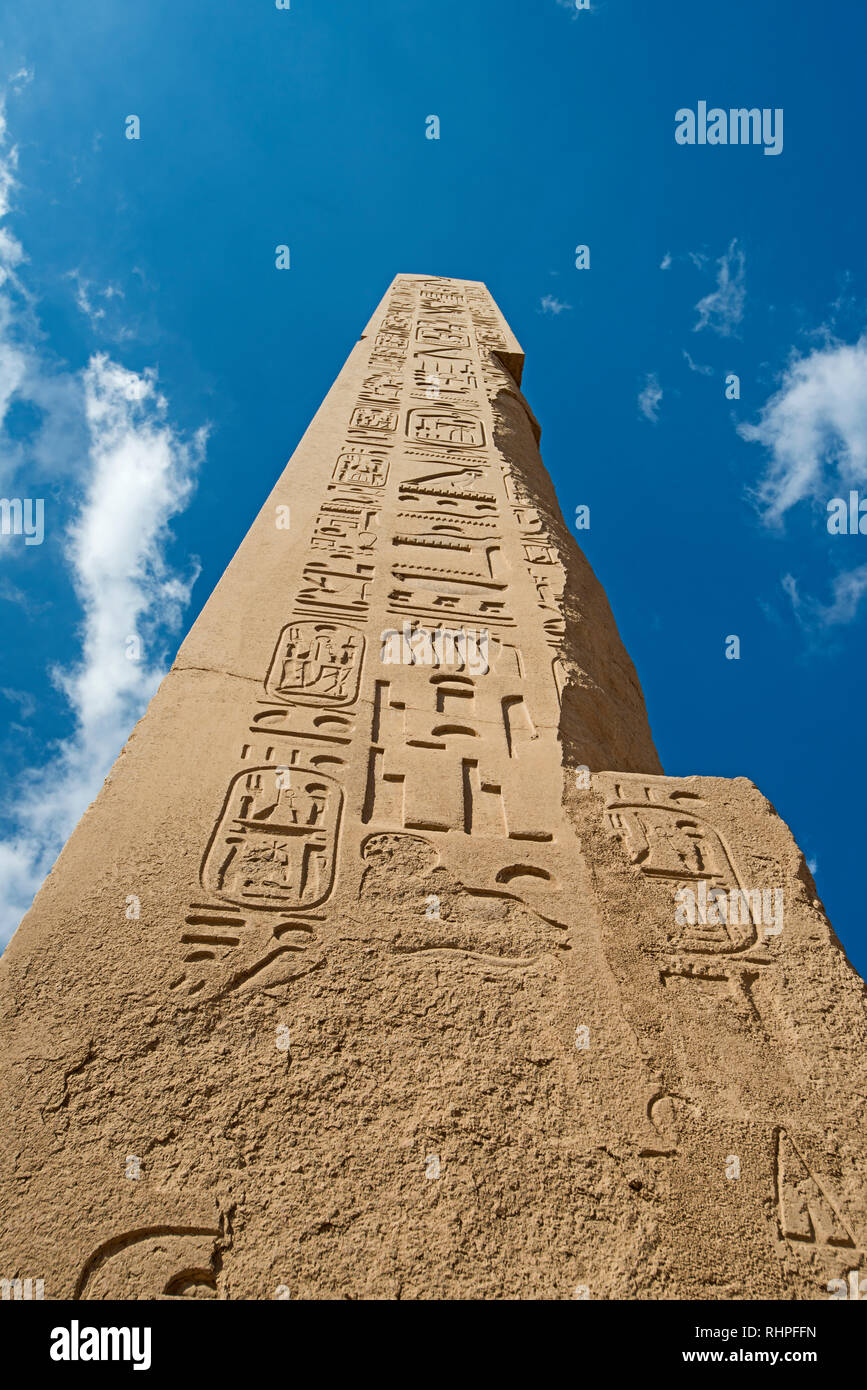 Large tall ancient egyptian obelisk at the temple of Karnak in Luxor with hieroglyphic carvings ...