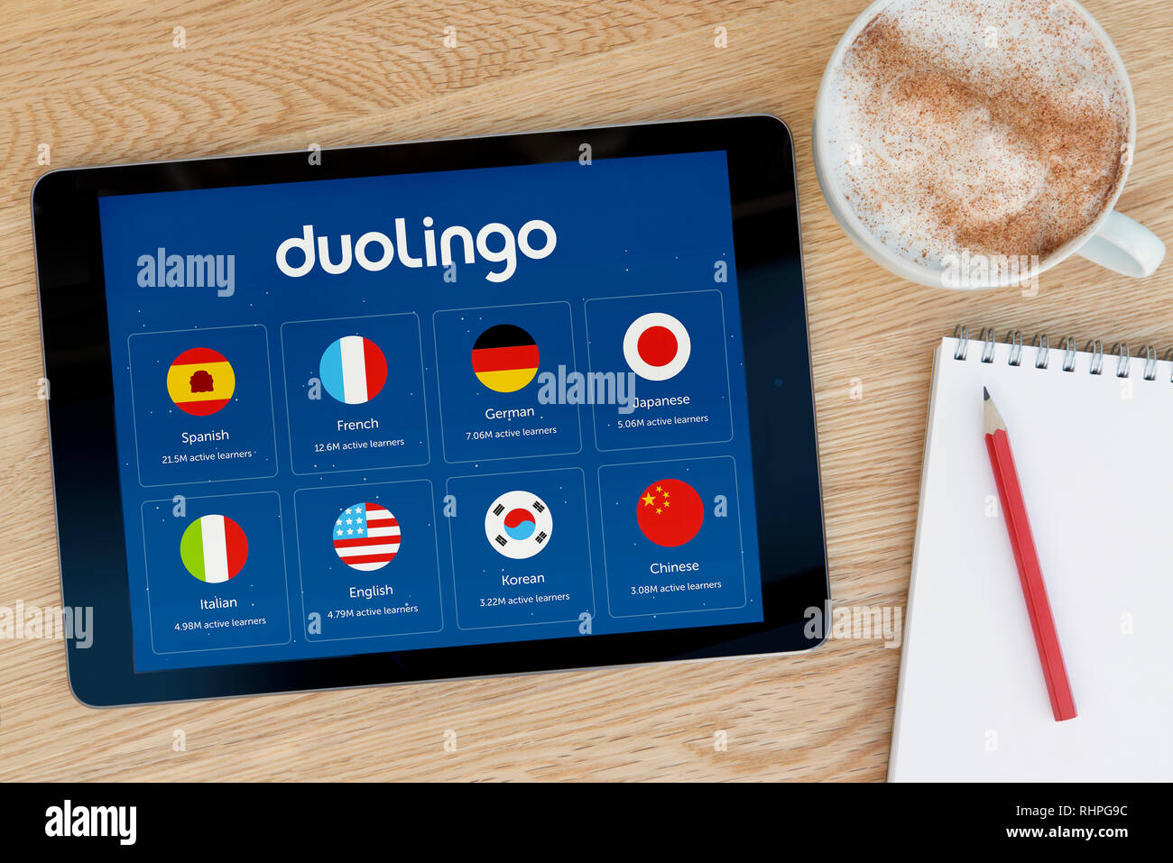 The Duolingo website features on an iPad tablet device which rests on a ...