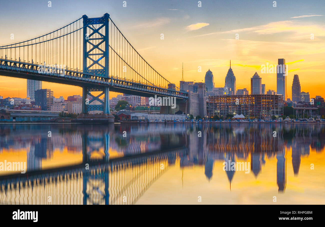 Philadelphia sunset skyline and Ben Franklin Bridge refection from across the Delaware River ...
