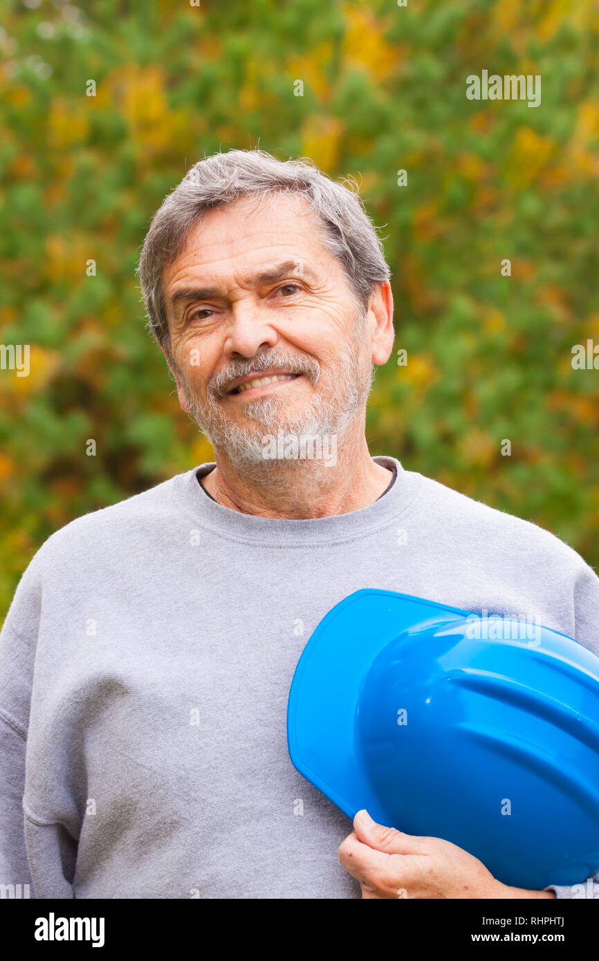 Contractor Builder with blue hardhat smiling Stock Photo - Alamy
