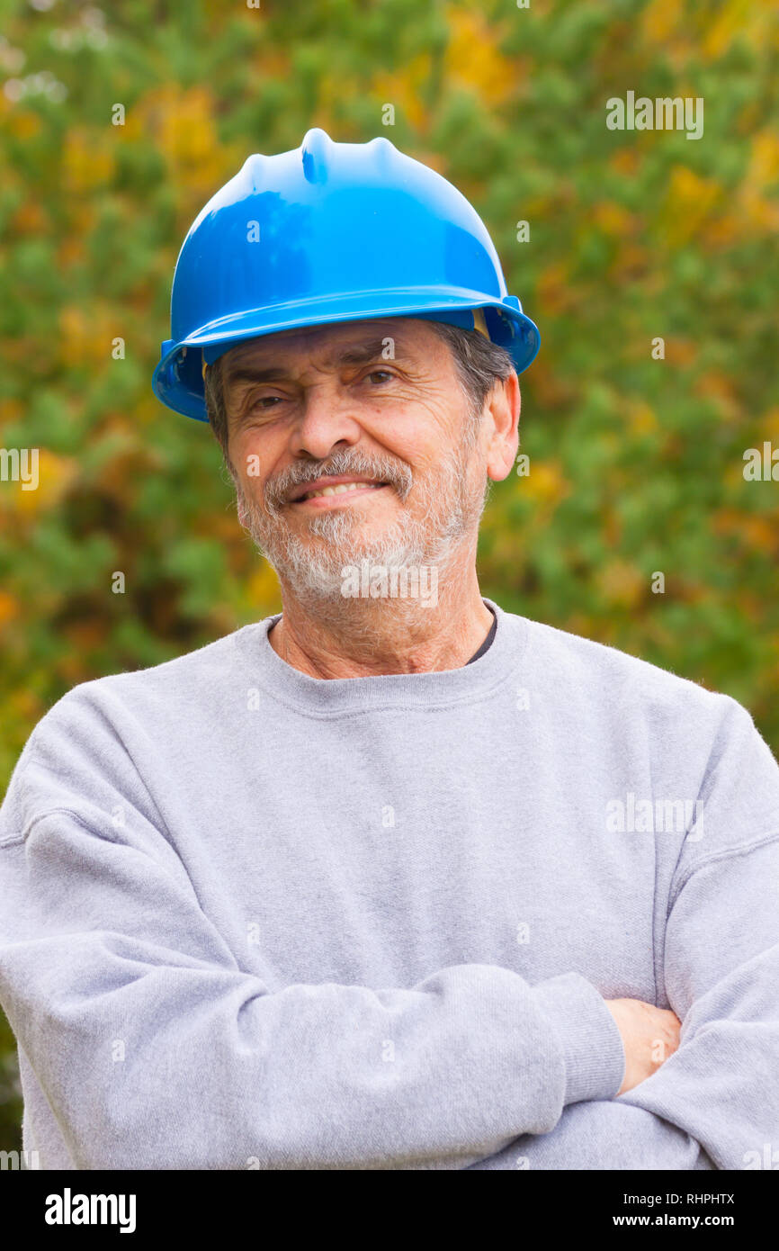 Contractor Builder with blue hardhat smiling Stock Photo - Alamy
