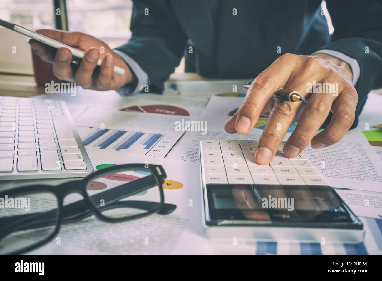Businessman or accountant working on calculator to calculate business ...
