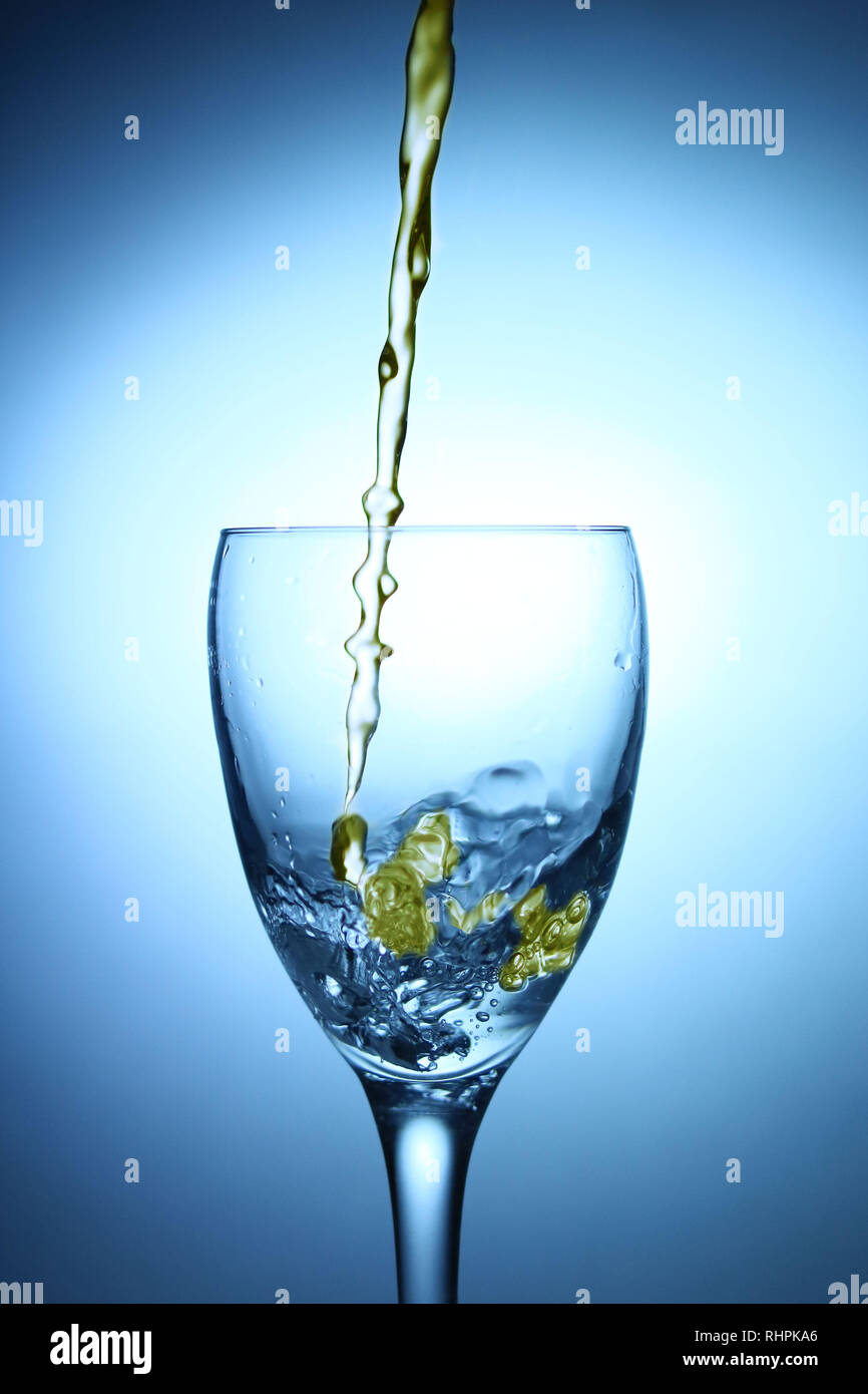 Oil splashing into a glass of water Stock Photo - Alamy