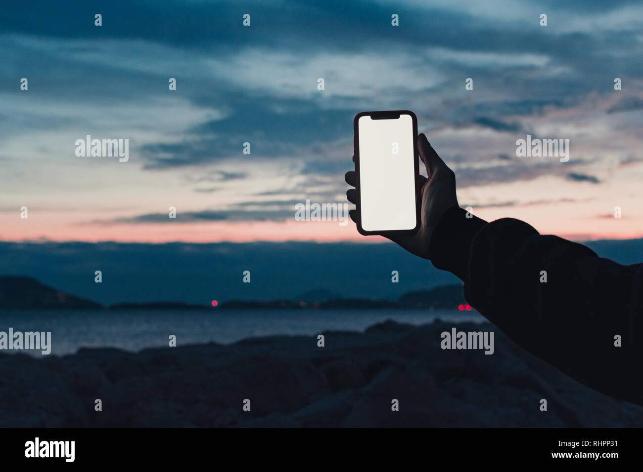 hand holding smart phone with landscape background with copy space ...