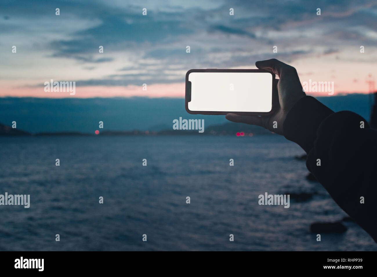 hand holding smart phone with landscape background with copy space ...