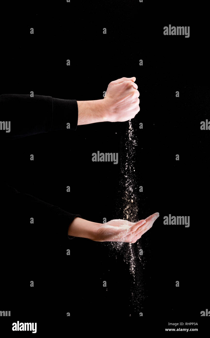 powder explosion with hand isolated on black background Stock Photo - Alamy