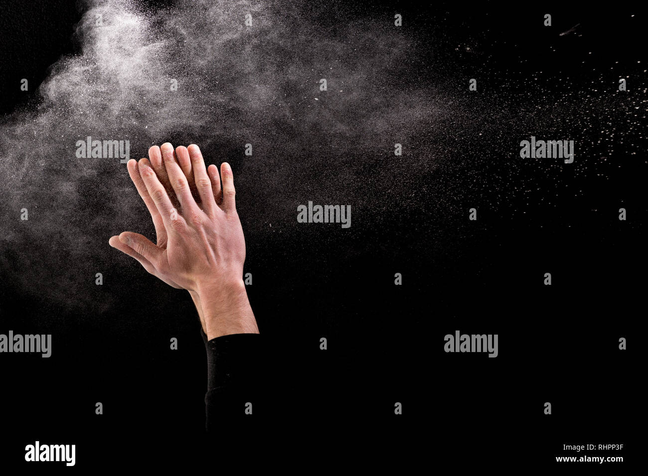 powder explosion with hand isolated on black background Stock Photo - Alamy