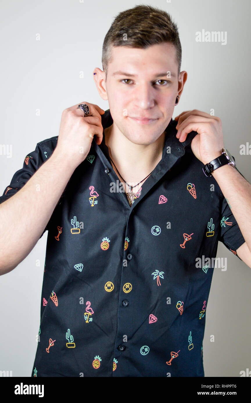 Portrait of a young man adjusting his shirt Stock Photo - Alamy
