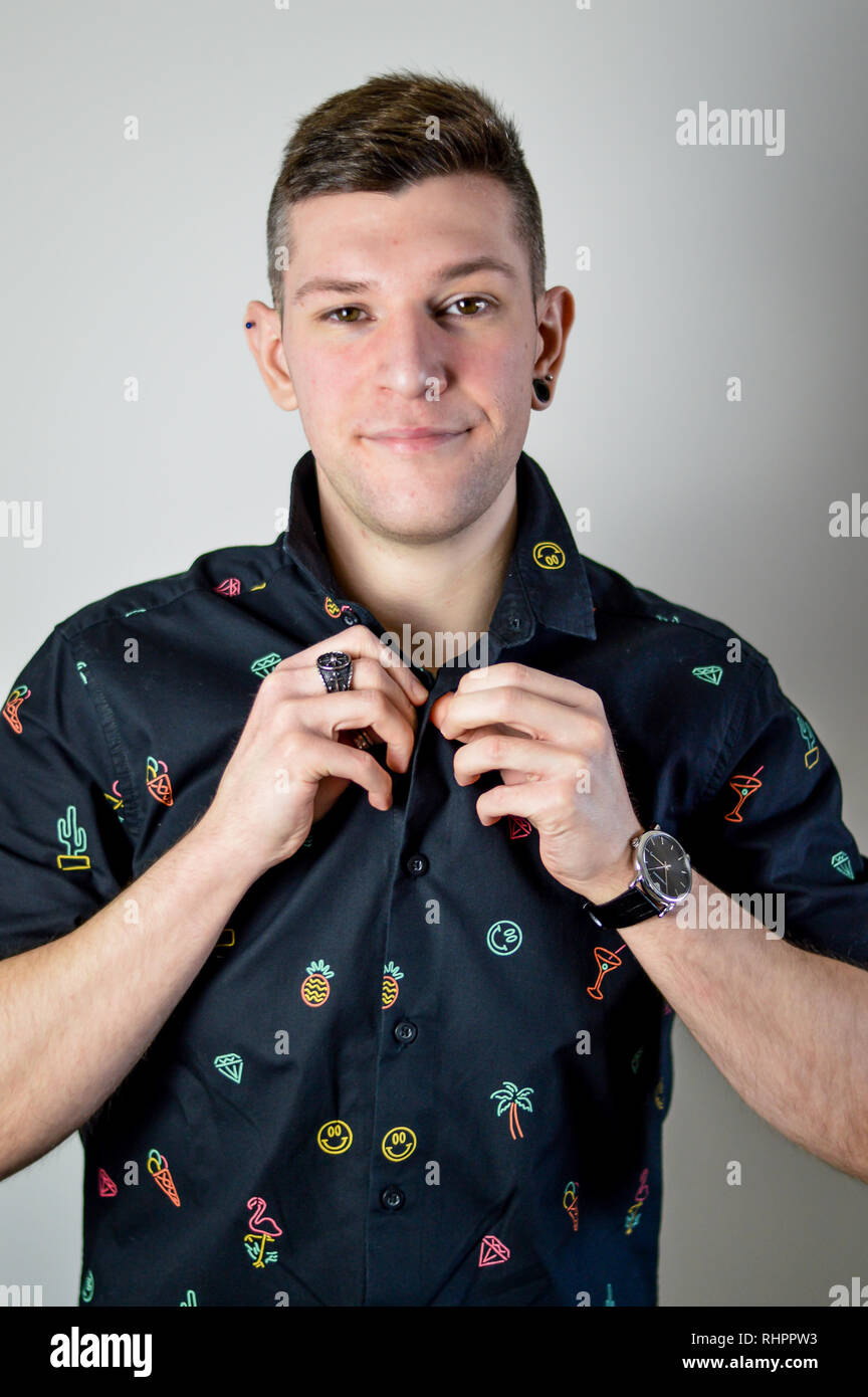 Portrait of a young man adjusting his shirt Stock Photo - Alamy
