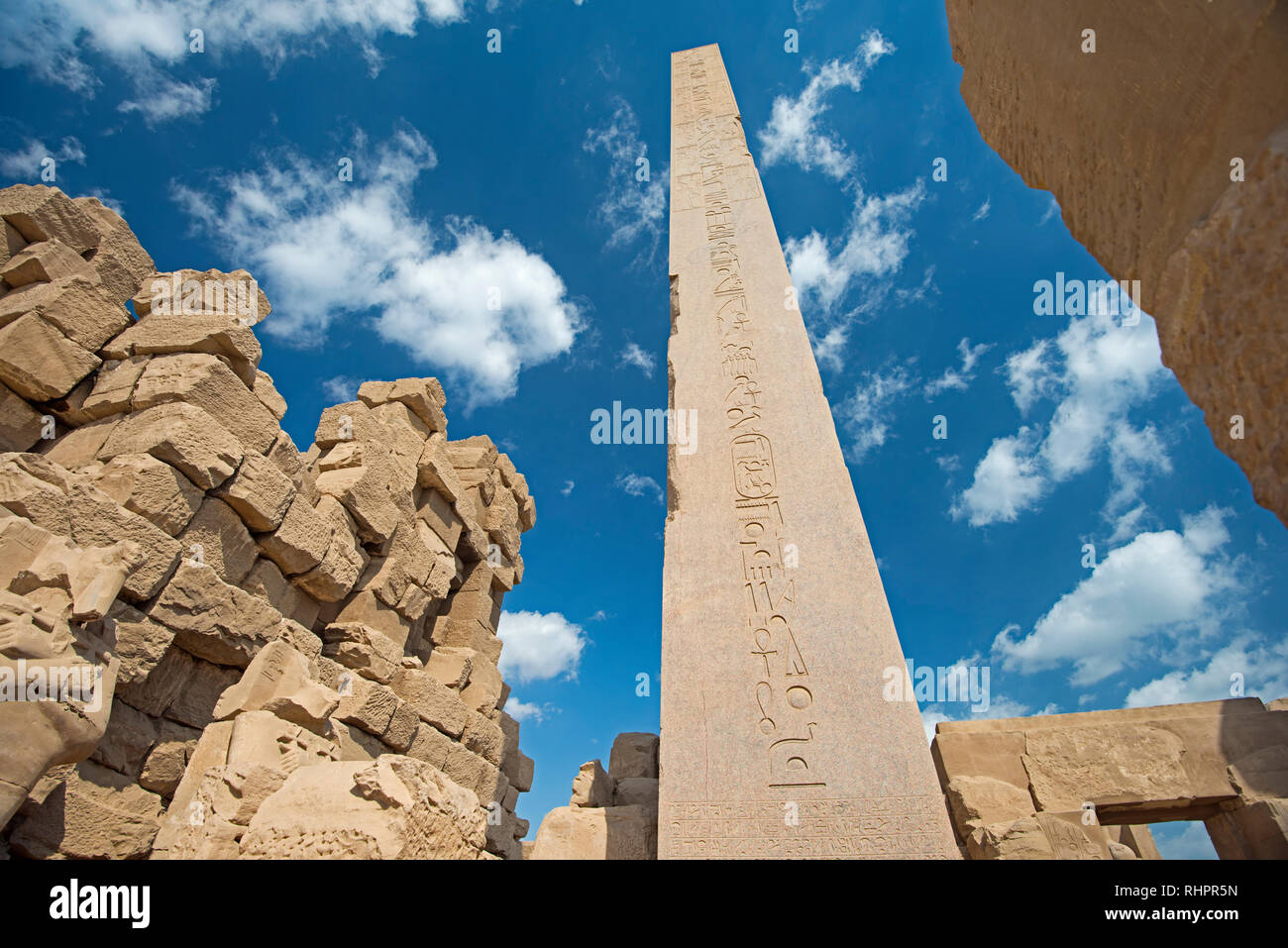 Large tall ancient egyptian obelisk at the temple of Karnak in Luxor with hieroglyphic carvings ...